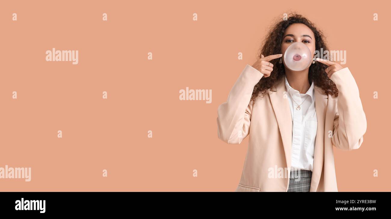 Beautiful African-American woman with chewing gum on color background ...