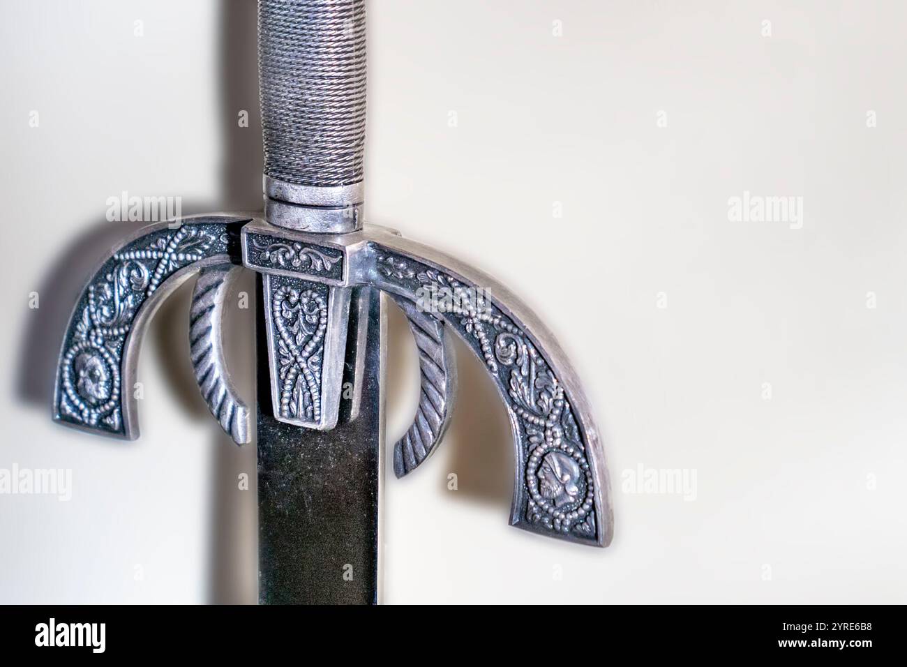 Ornate metal sword hilt with light background Stock Photo - Alamy