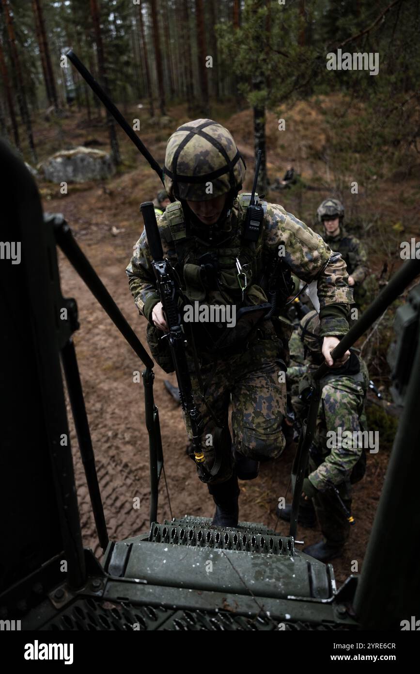 A Finnish servicemember climbs into a medium tactical vehicle ...