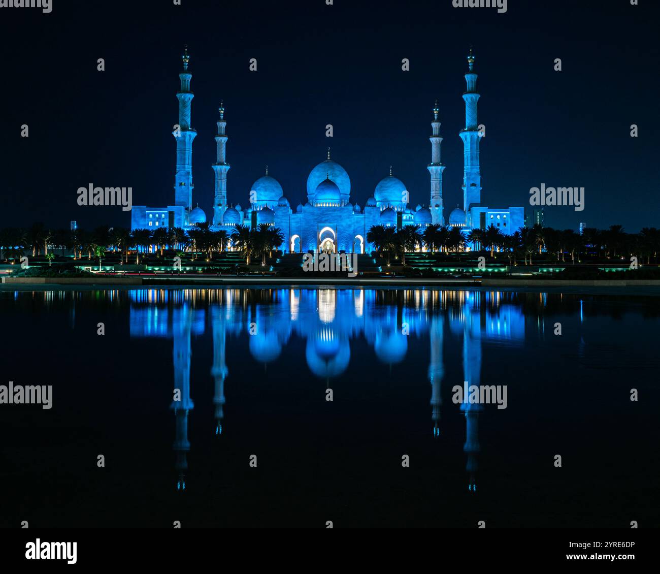 Sheikh Zayed Grand Mosque illuminated in vibrant blue during nighttime ...