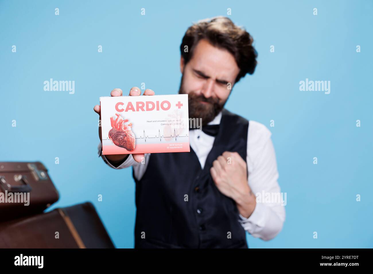 Doorman with heart condition holds pills against blue background ...