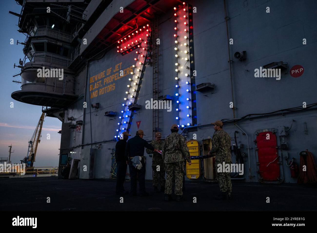 SAN DIEGO (Nov. 21, 2024) U.S. Navy Sailors conduct evening colors on the flight deck aboard the ...