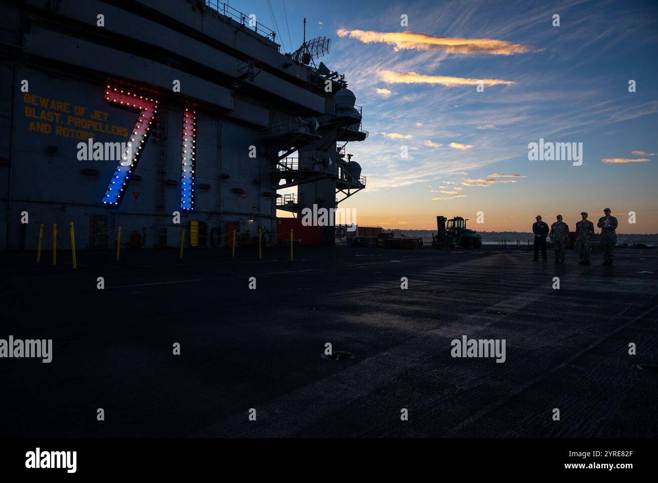 SAN DIEGO (Nov. 21, 2024) U.S. Navy Sailors conduct evening colors on the flight deck aboard the ...