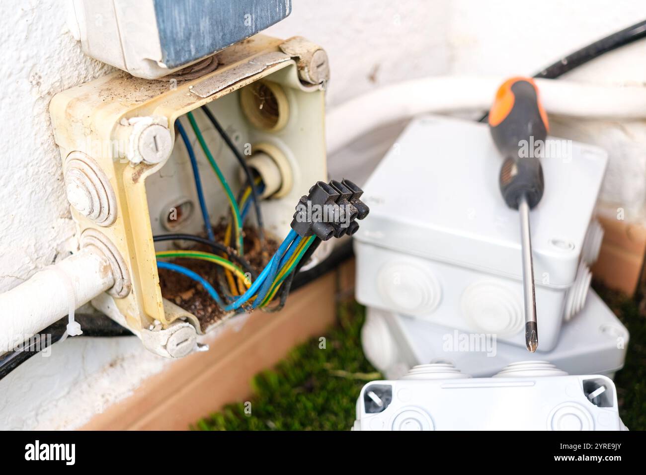 A damaged outdoor electrical cable box is being replaced with a new ...