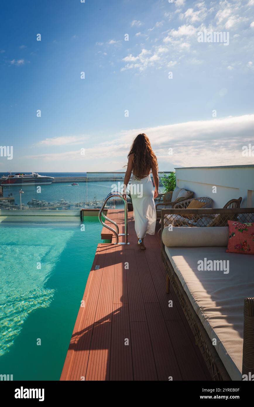 Woman in White Dress by Infinity Pool Overlooking Harbor Stock Photo ...
