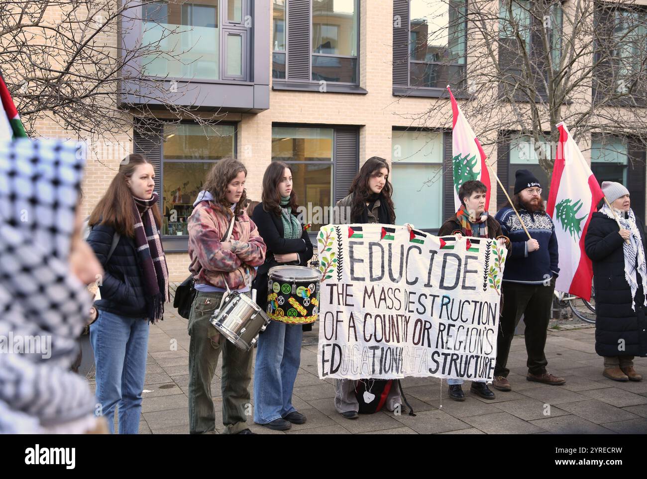 Protesters listen to poems with a banner saying ‘Educide, The Mass ...