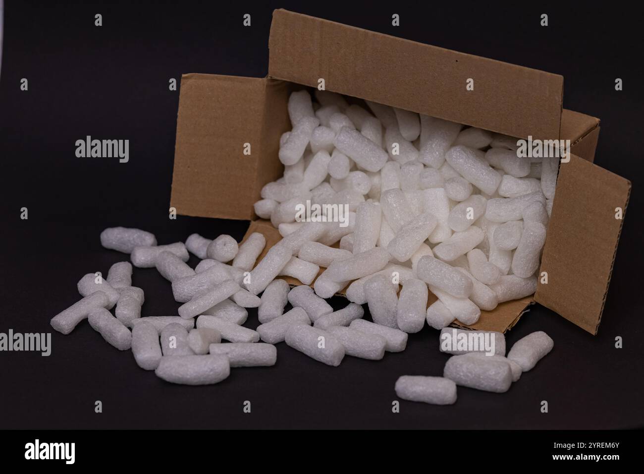 Open cardboard box spilling white polystyrene foam packing peanuts on ...