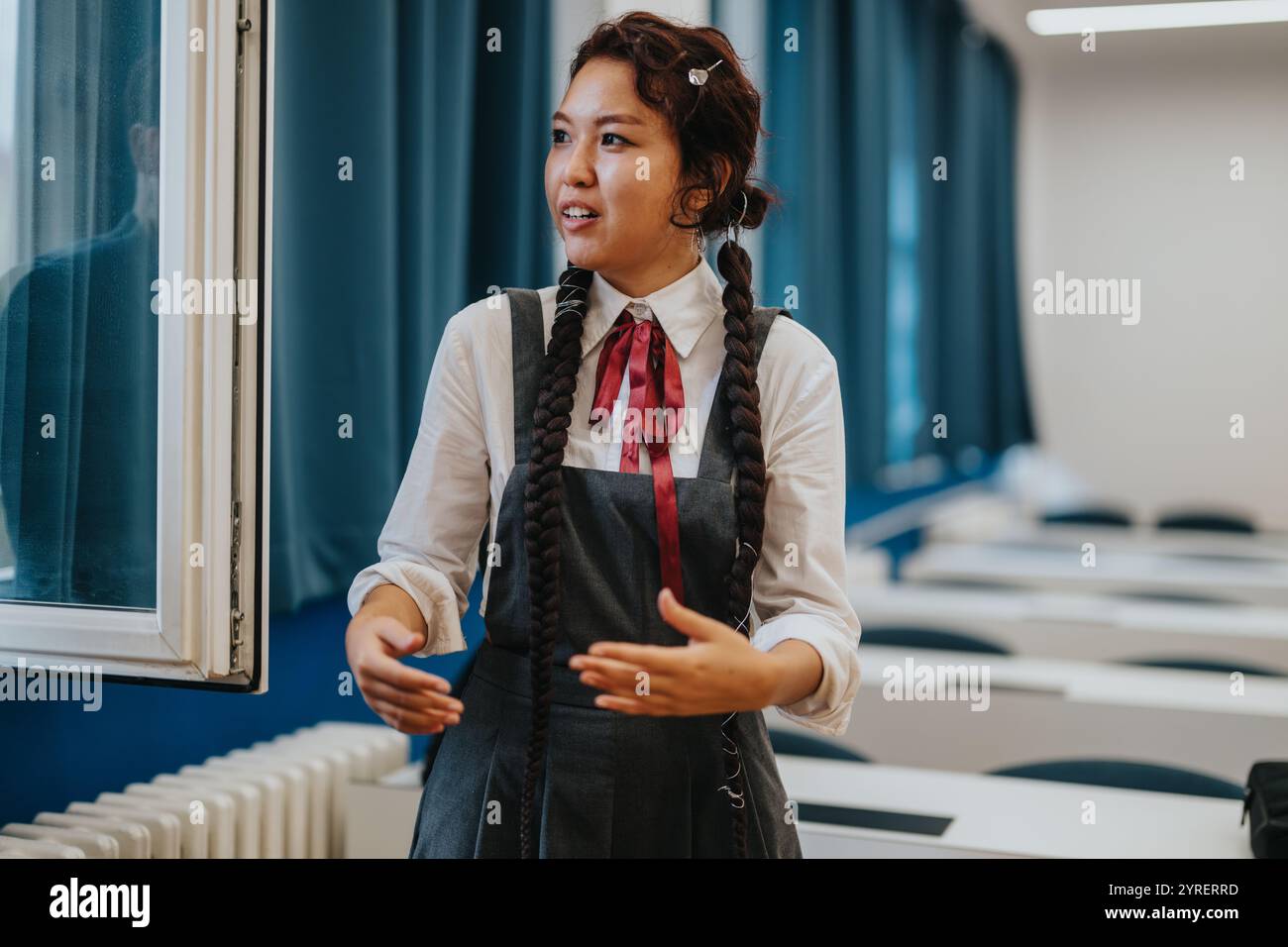 Student speaking in a classroom wearing a uniform with braids Stock ...