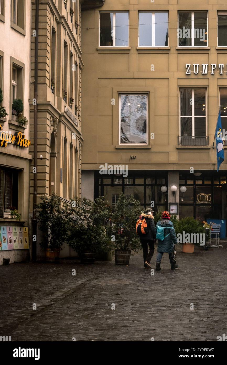 A lively Swiss street scene with people walking, surrounded by charming ...