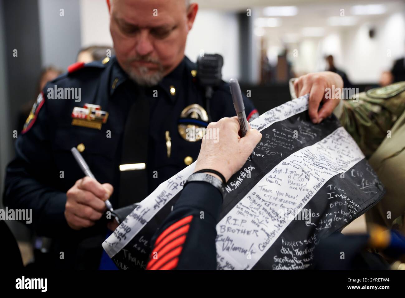 Greenville Police Officers write their remarks on a flag ahead of the ...