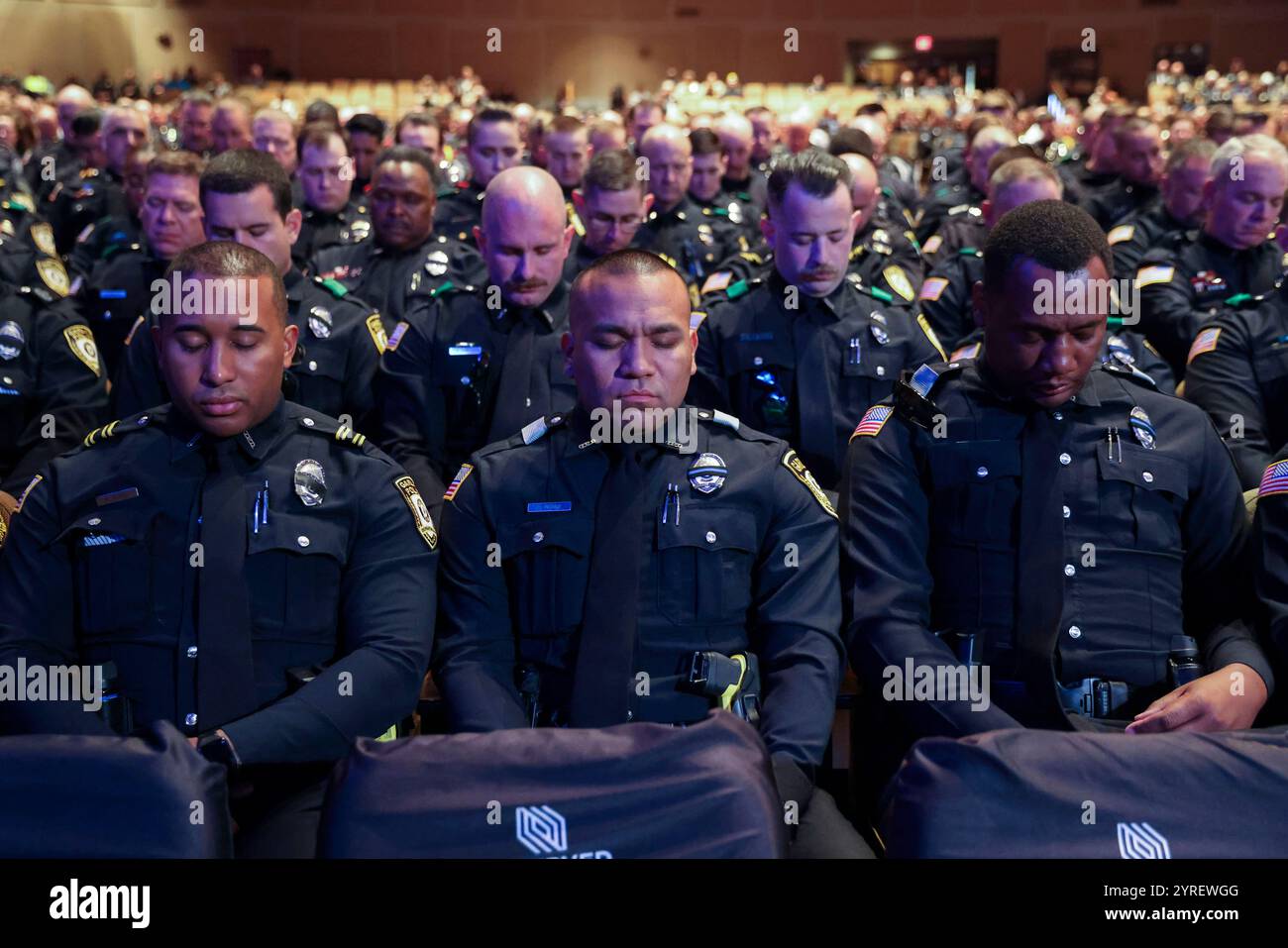 Members of Garland Police Department join the rest in praying during a ...