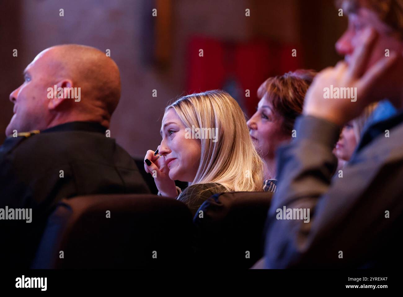 Aubrey Dawson, wipes away tears as she watches a slideshow shown during ...