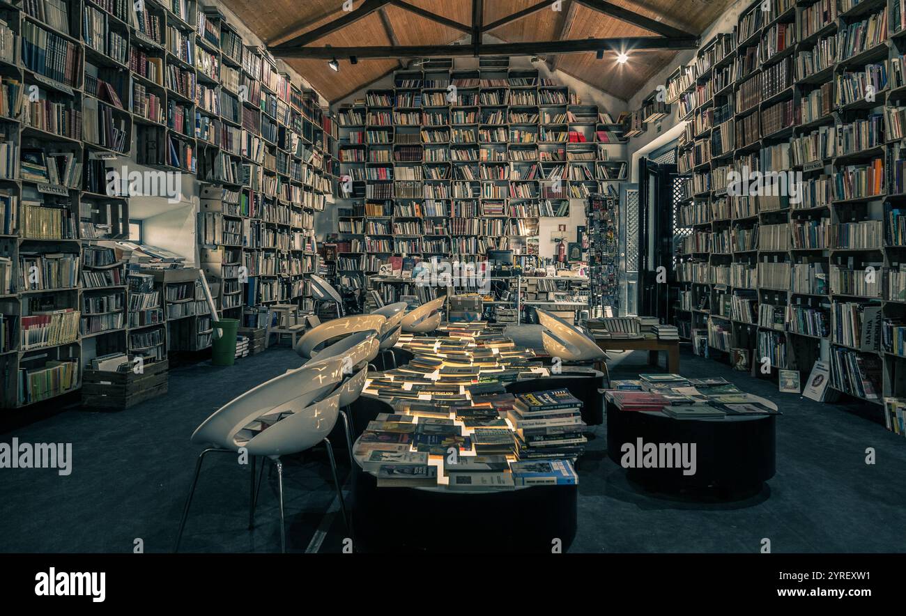 Books are neatly arranged on shelves and tables in a library, creating ...