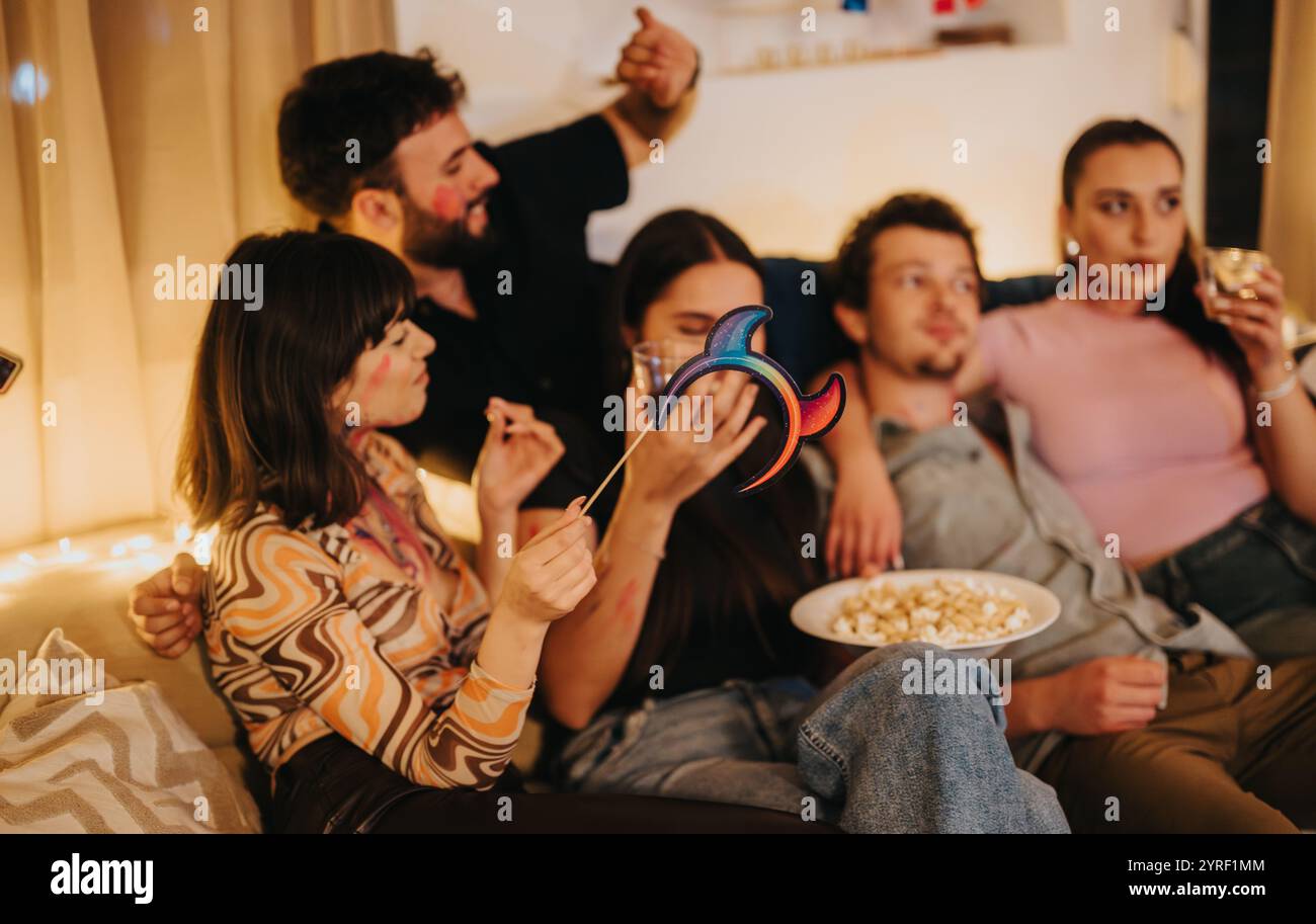 Friends enjoying a cozy indoor birthday party with snacks and drinks ...