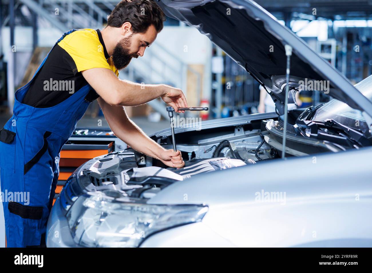 Engineer expertly examines car engine using advanced mechanical tools ...
