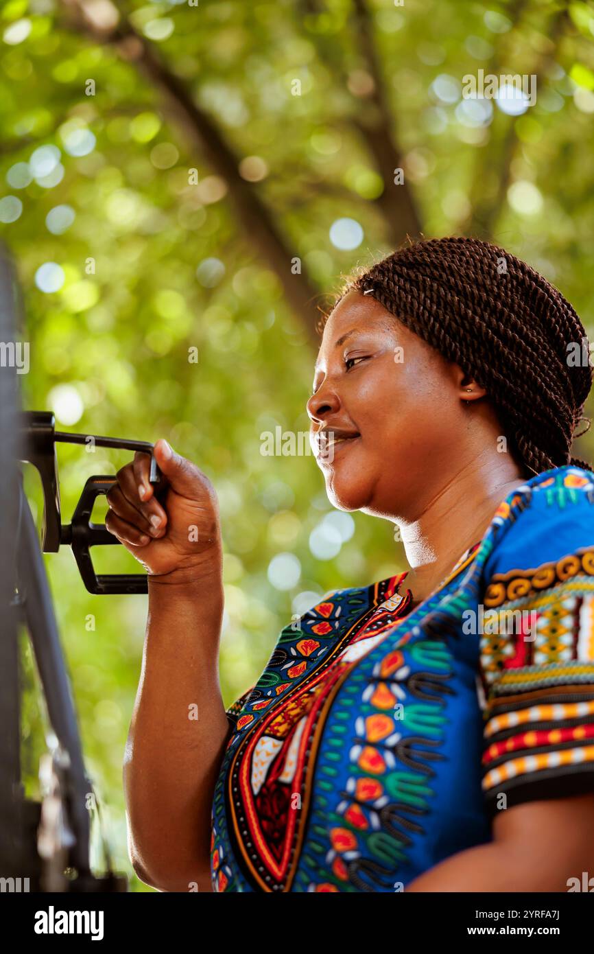 Sports-loving african american lady adjusting components with allen key ...