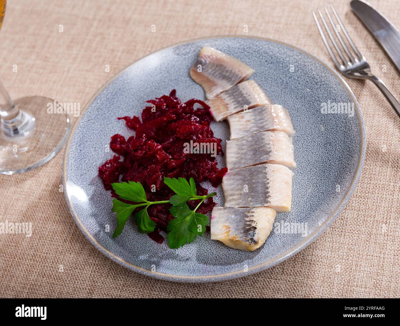 On round blue plate - lightly salted herring fillet cut into pieces ...