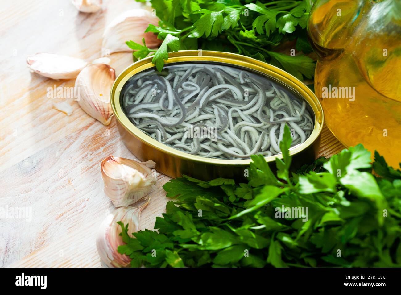 Pickled eels in open tin can with garlic at table Stock Photo - Alamy