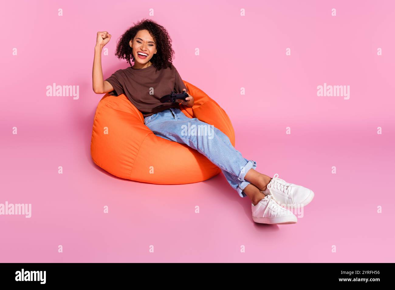 Full body photo of attractive young woman playstation sit bean bag ...