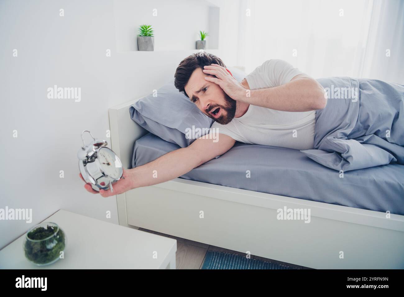 Photo of tired stressed mature guy dressed sleepwear lying bed oversleeping indoors room home ...