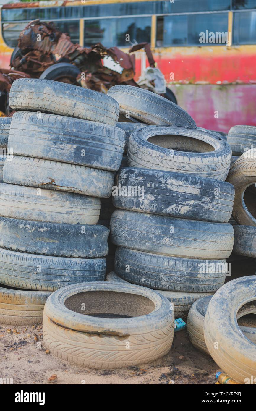 A pile of discarded tires in a junkyard, taking up space and posing a potential environmental ...