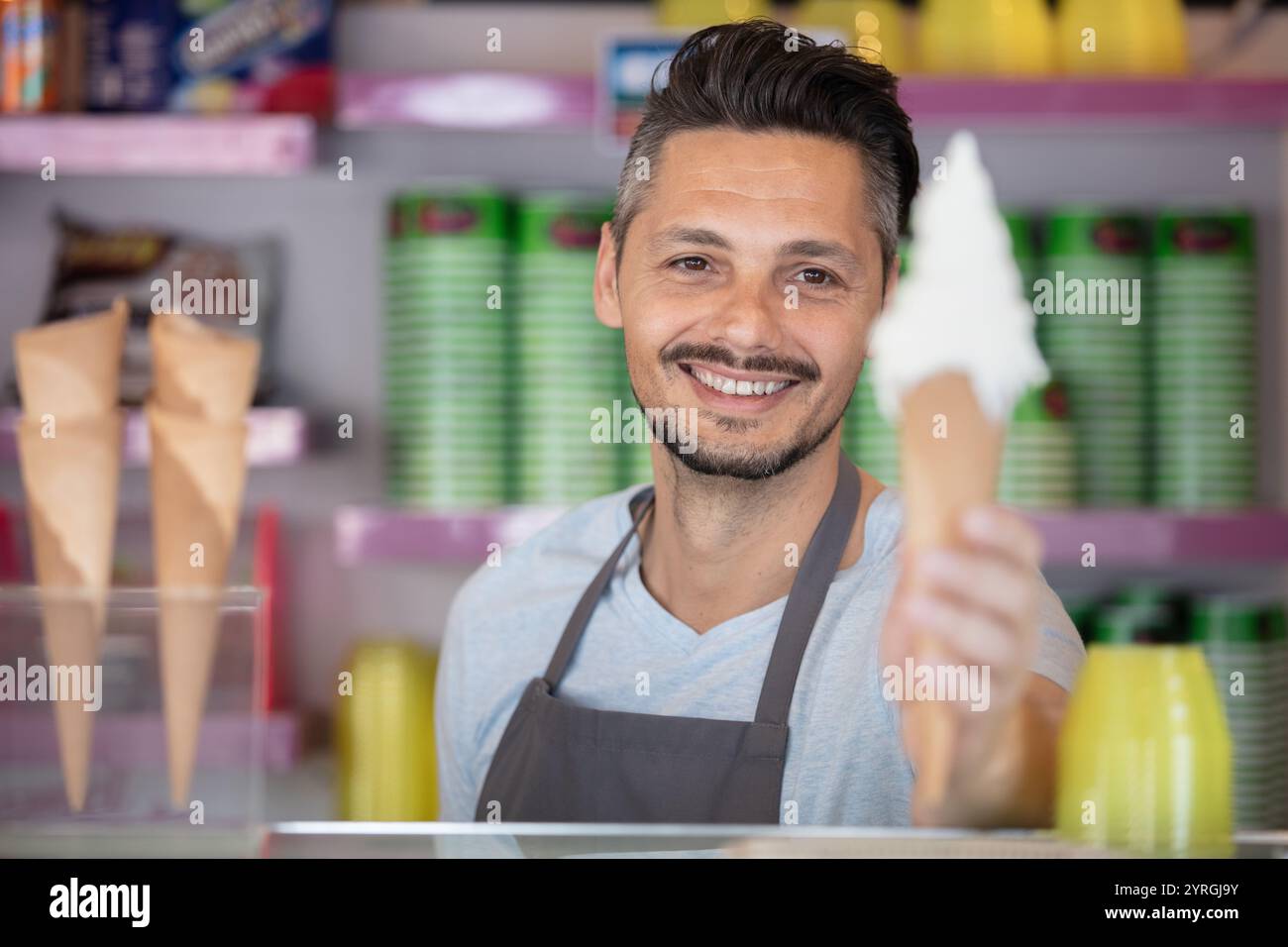 man serving ice cream with apron Stock Photo - Alamy