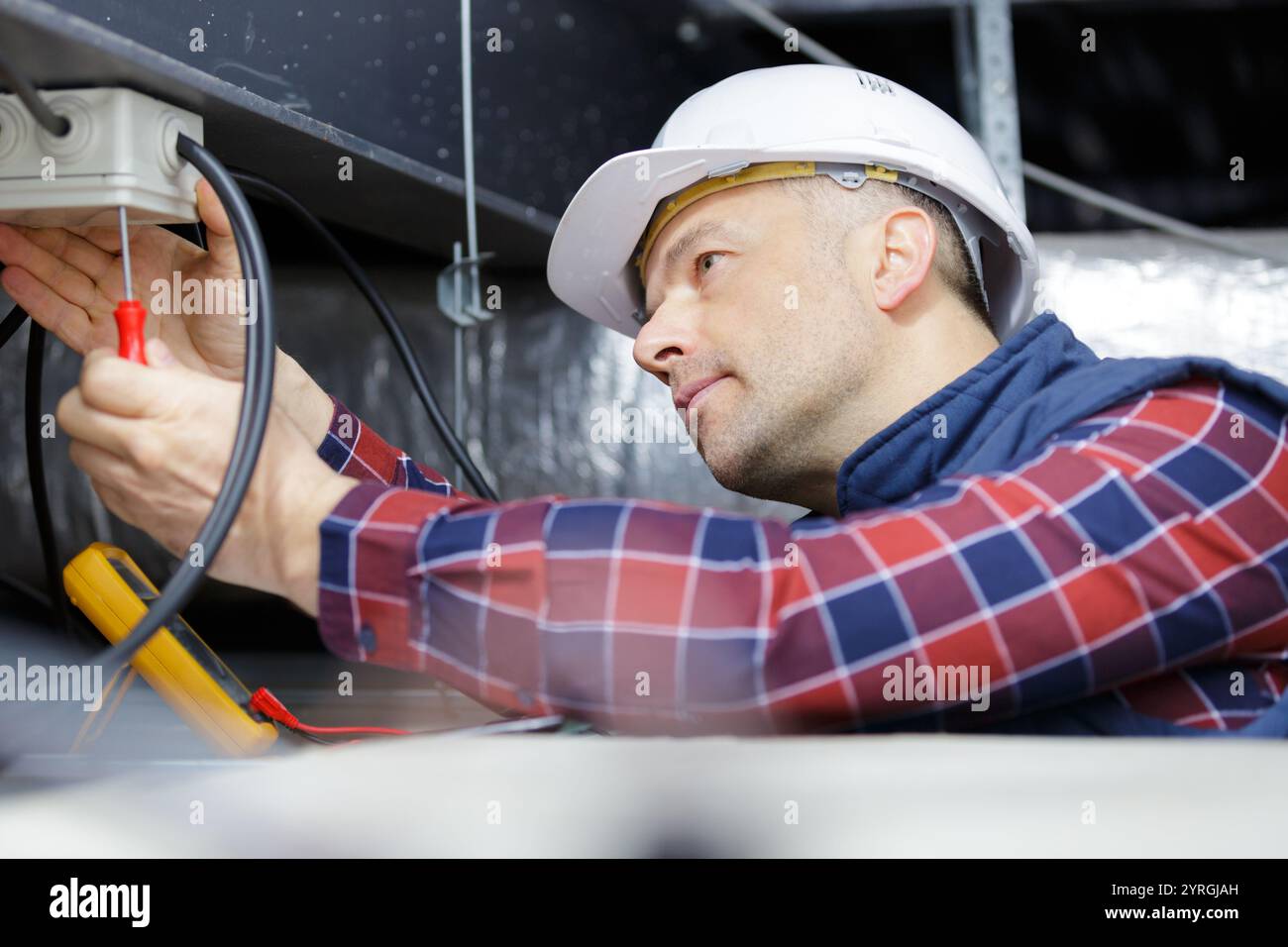 worker making mounting for an electric cable in ceiling Stock Photo - Alamy