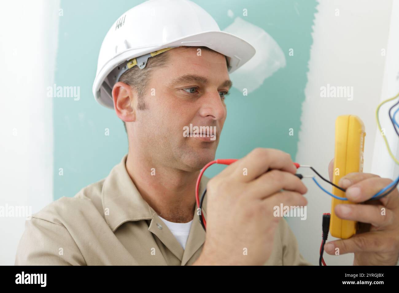 happy electrician checking voltage in electrical wall socket Stock ...