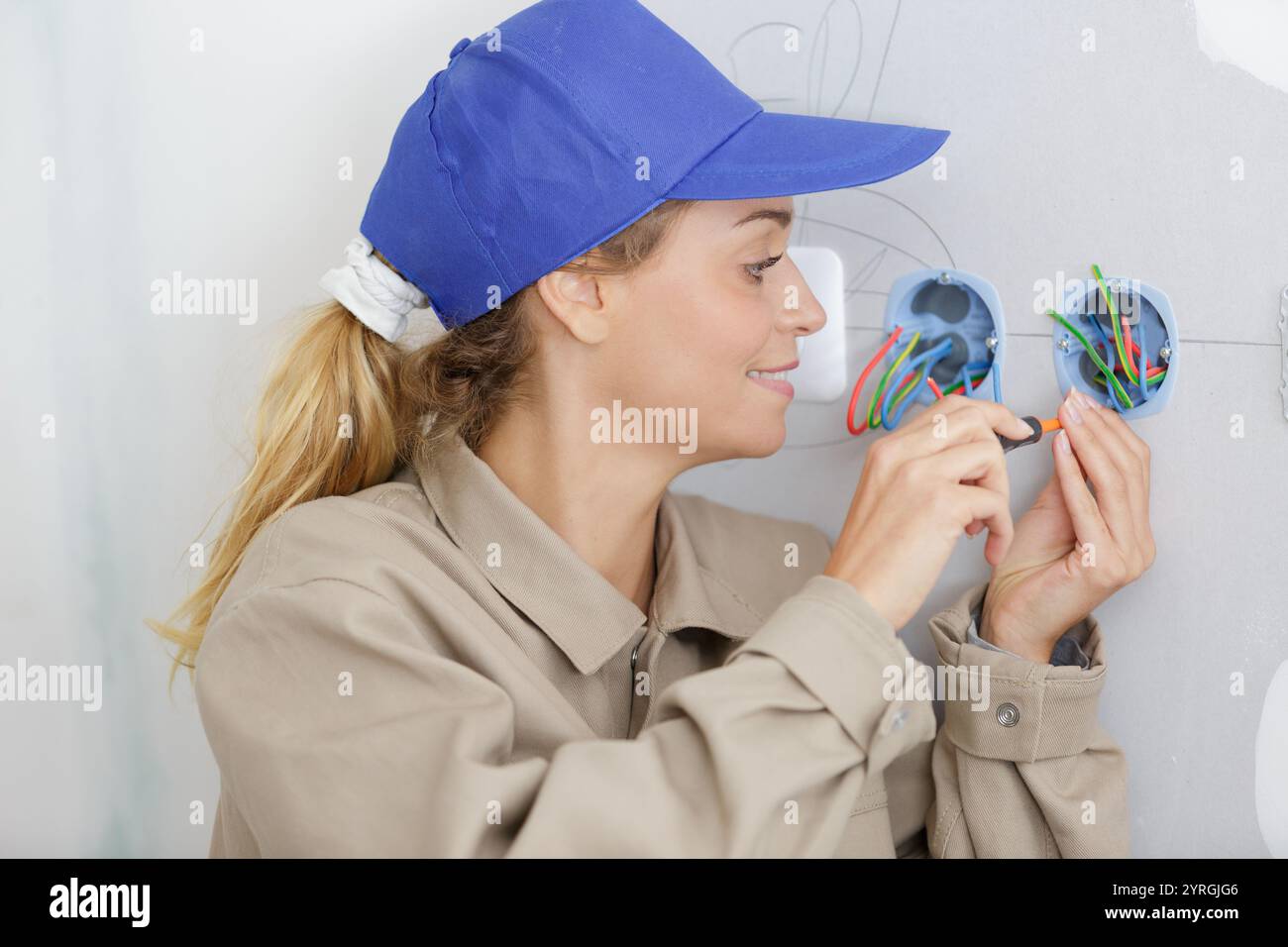 Female electrician fixing socket hi-res stock photography and images ...