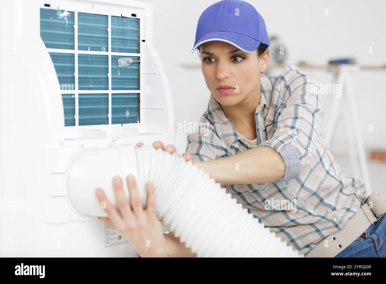 female air conditioning engineer fitting a pipe Stock Photo - Alamy