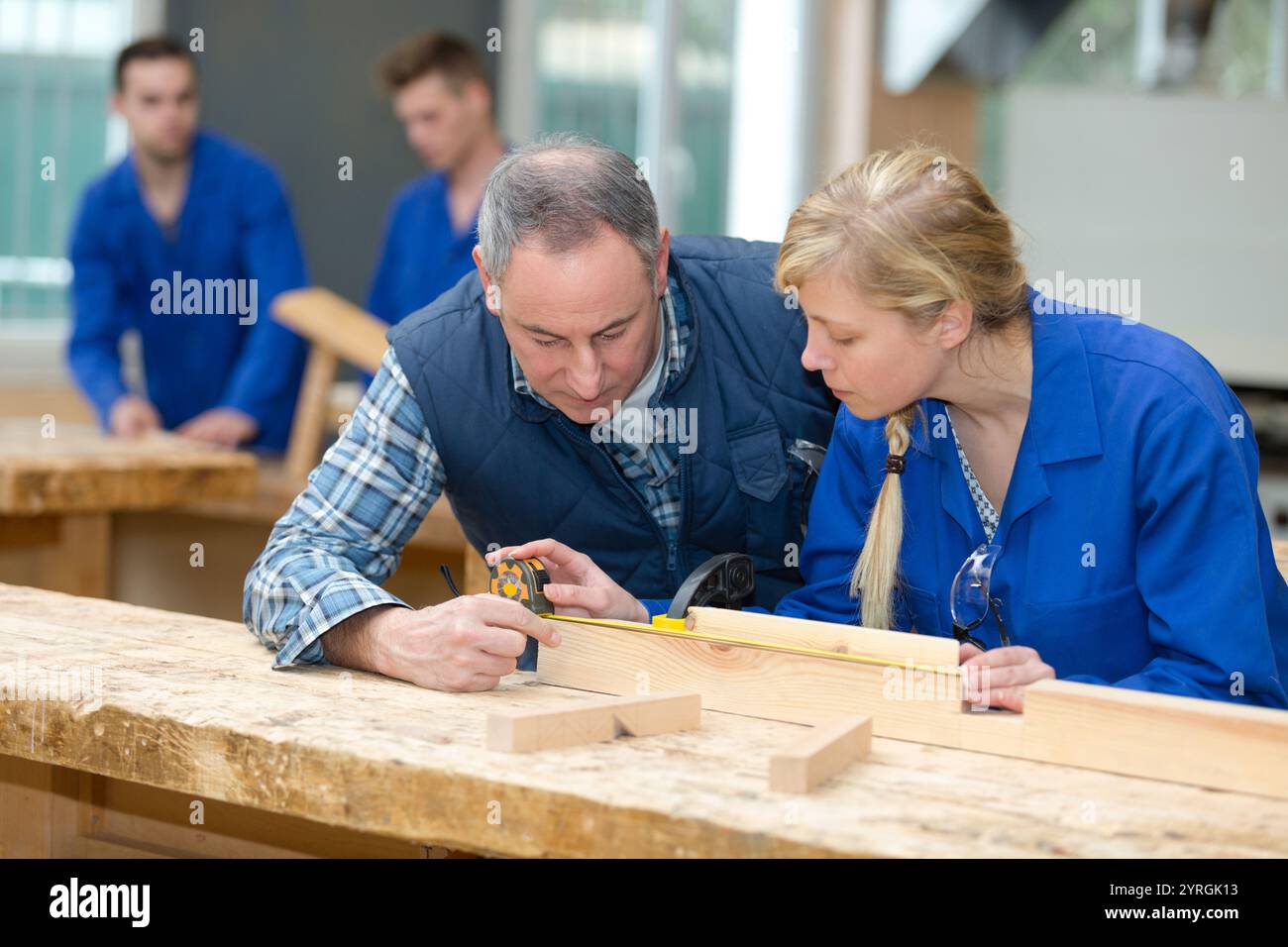 carpentry worker and apprentice measuring wood Stock Photo - Alamy