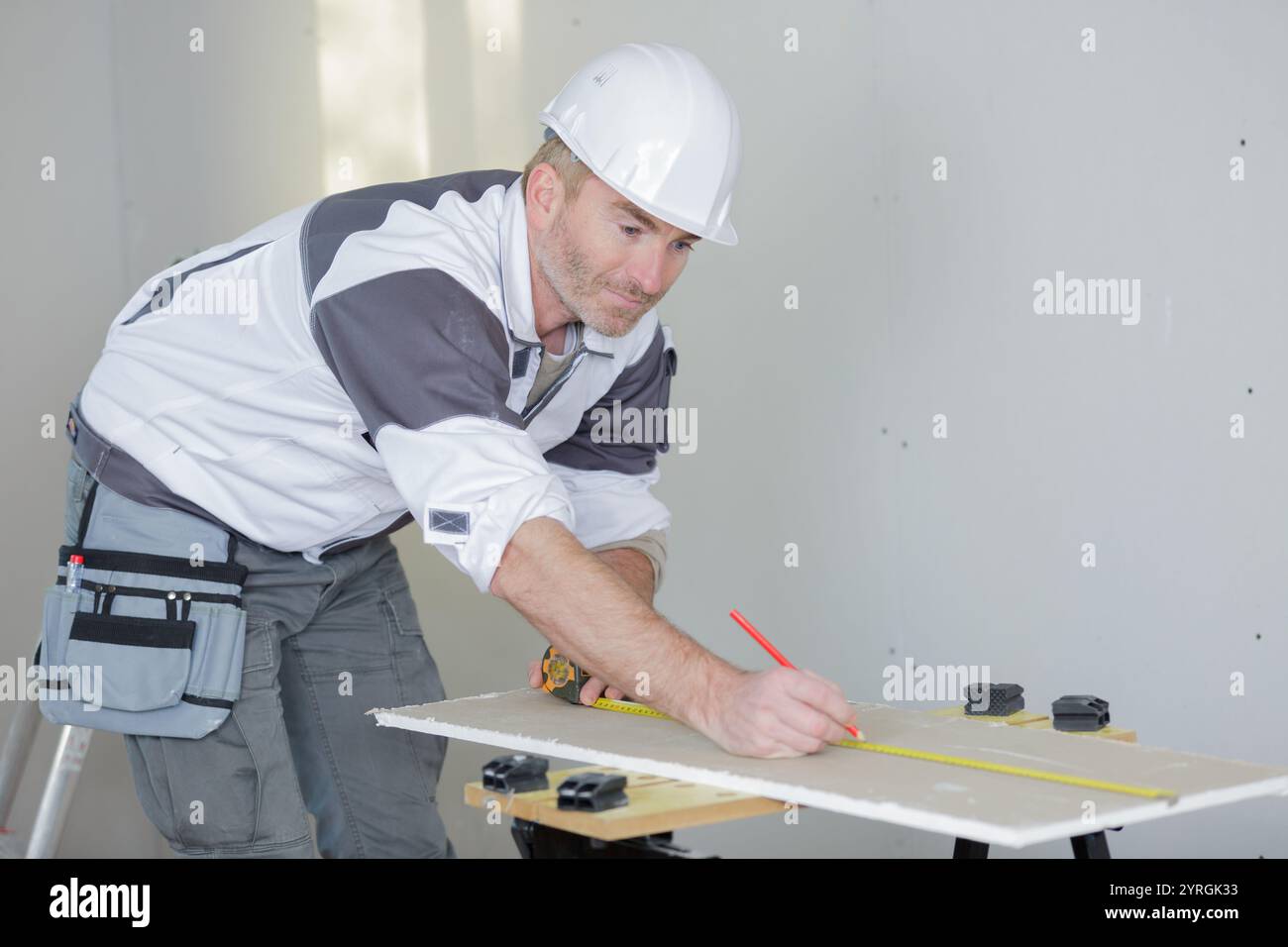 carpenter with ruler and blueprint at workshop Stock Photo - Alamy