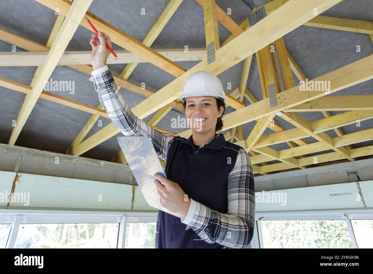 female contractor pointing to wooden beams Stock Photo - Alamy