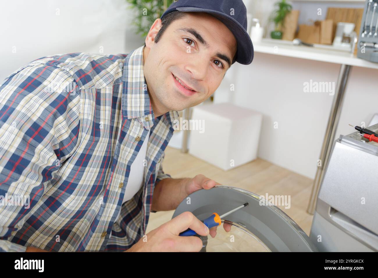 happy nice looking man checking a washing machine Stock Photo - Alamy