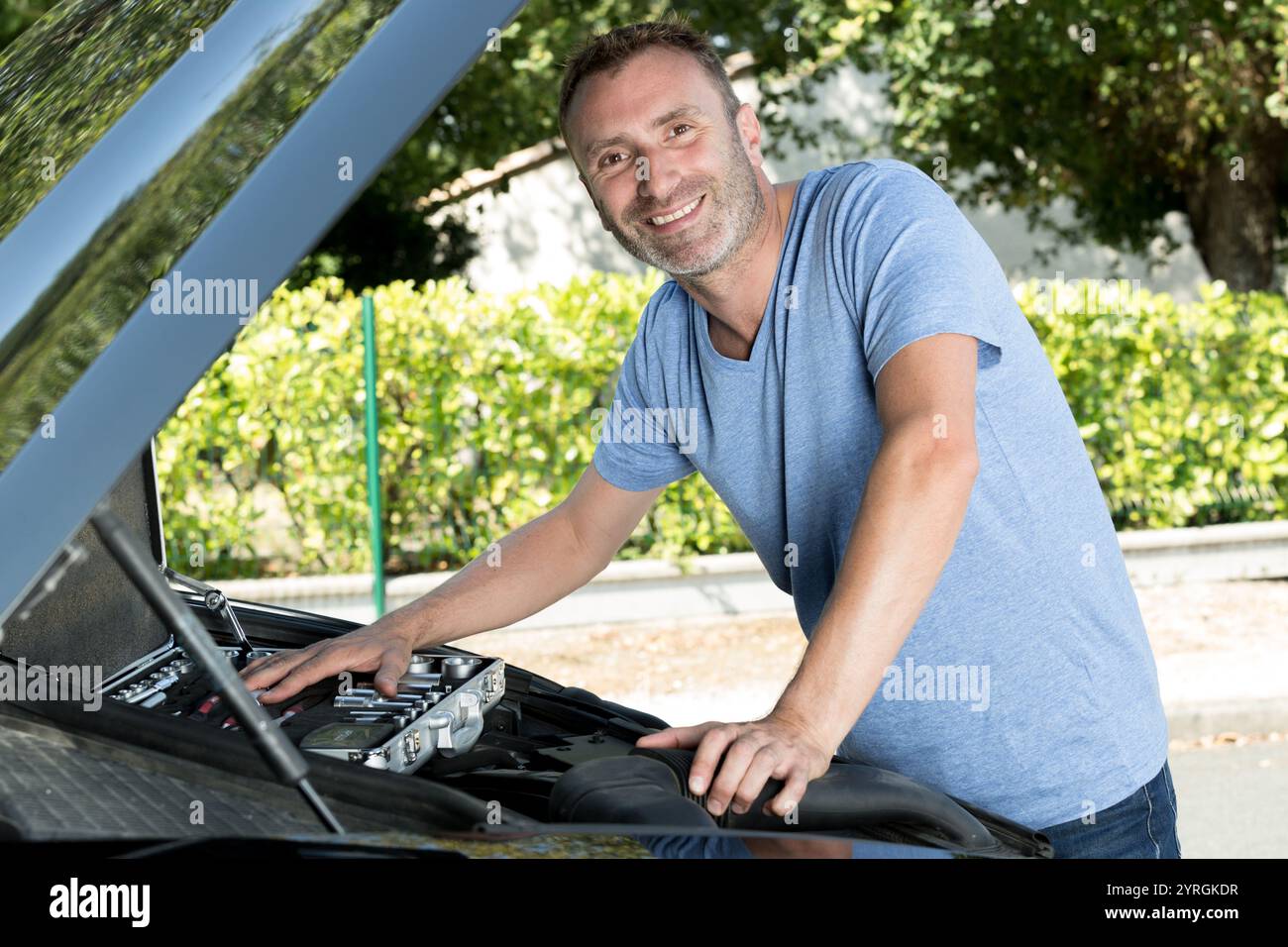 happy man fixing a car Stock Photo - Alamy