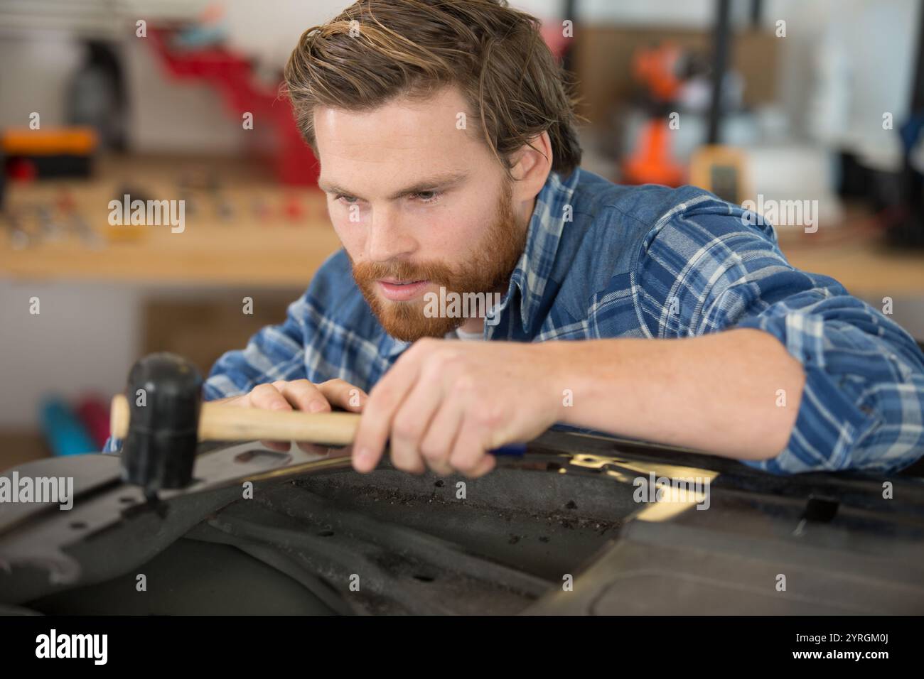 mechanic fixing a car door with a hammer Stock Photo - Alamy