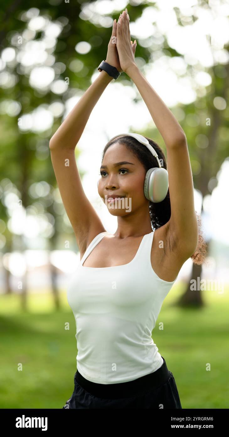 Attractive fit woman practicing meditation outdoors, standing with ...
