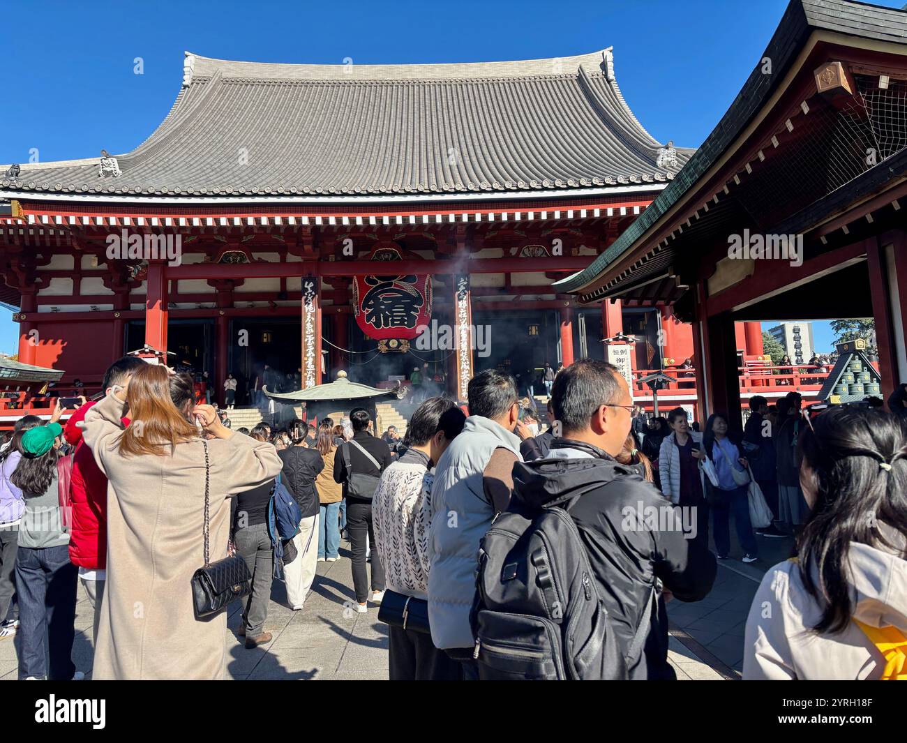 People praying outside the main building of Senso-ji Temple in the ...