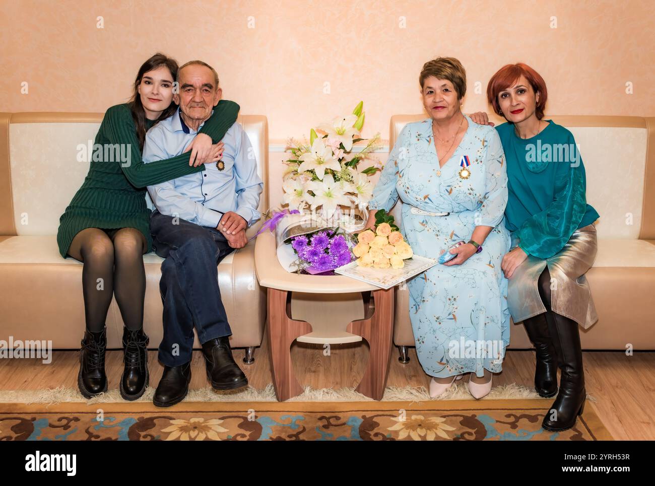 76-year-old man and 71-year-old woman celebrate their golden wedding anniversary, sitting on a ...