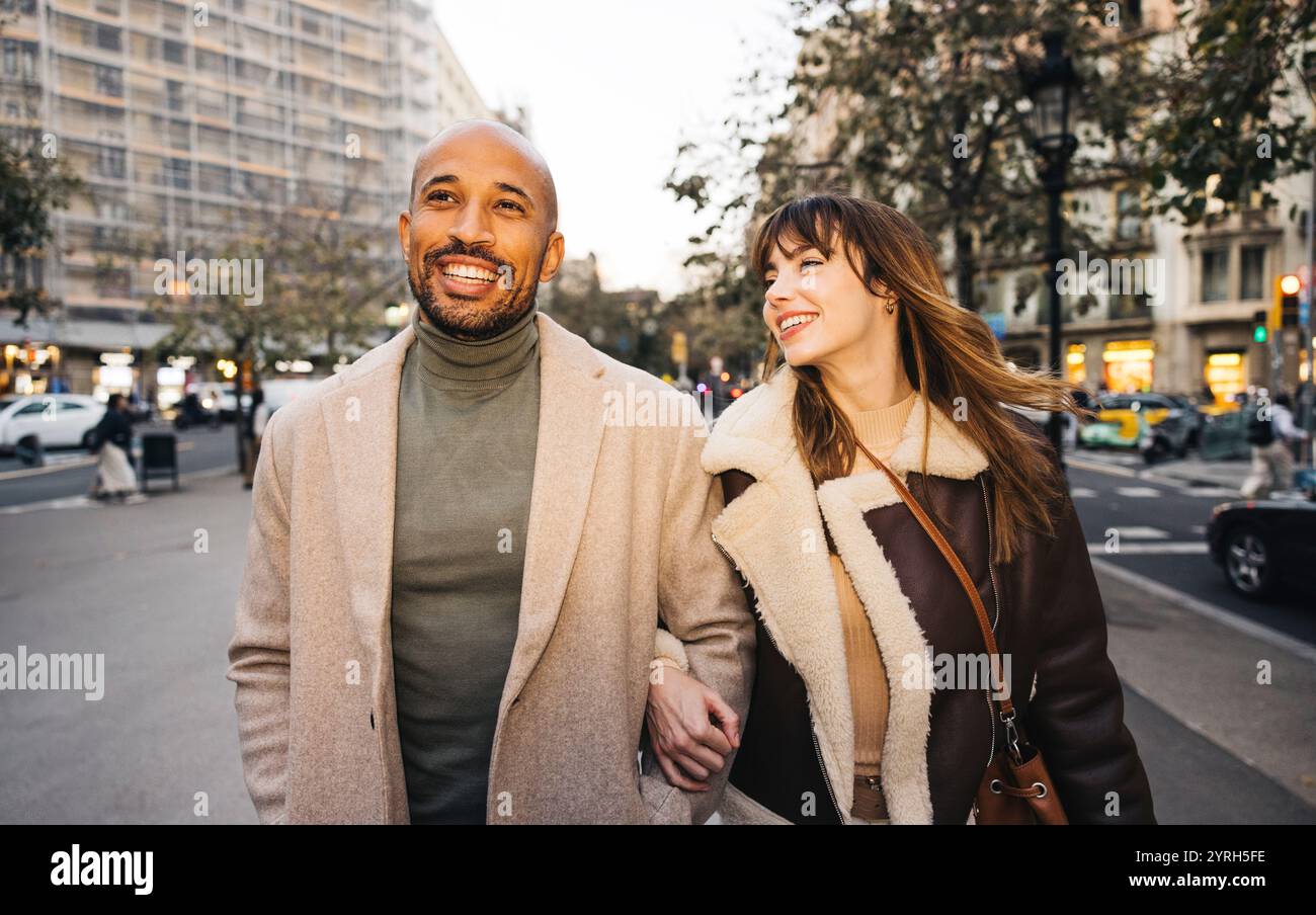 A joyful couple strolls hand in hand through city streets, enjoying a ...
