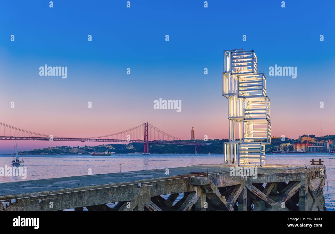 Illuminated modern art installation glowing at sunset on a pier in ...