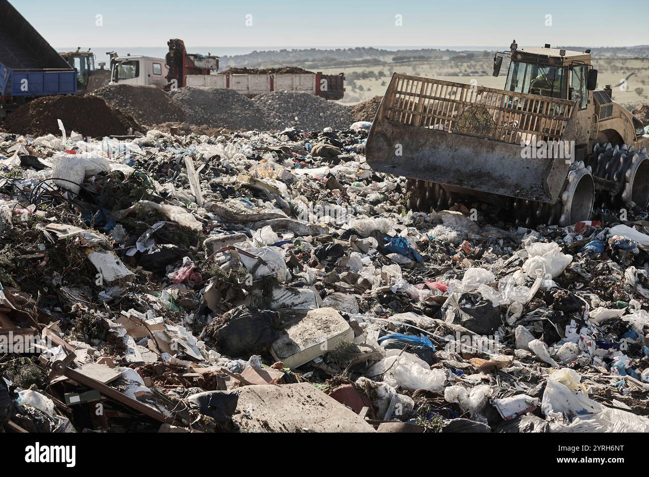 Heavy machinery shredding garbage in an open air landfill. Waste Stock ...