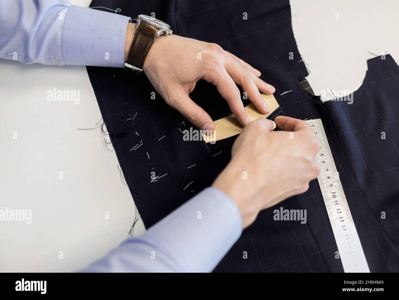 Professional tailor marking sewing pattern on fabric with chalk at ...