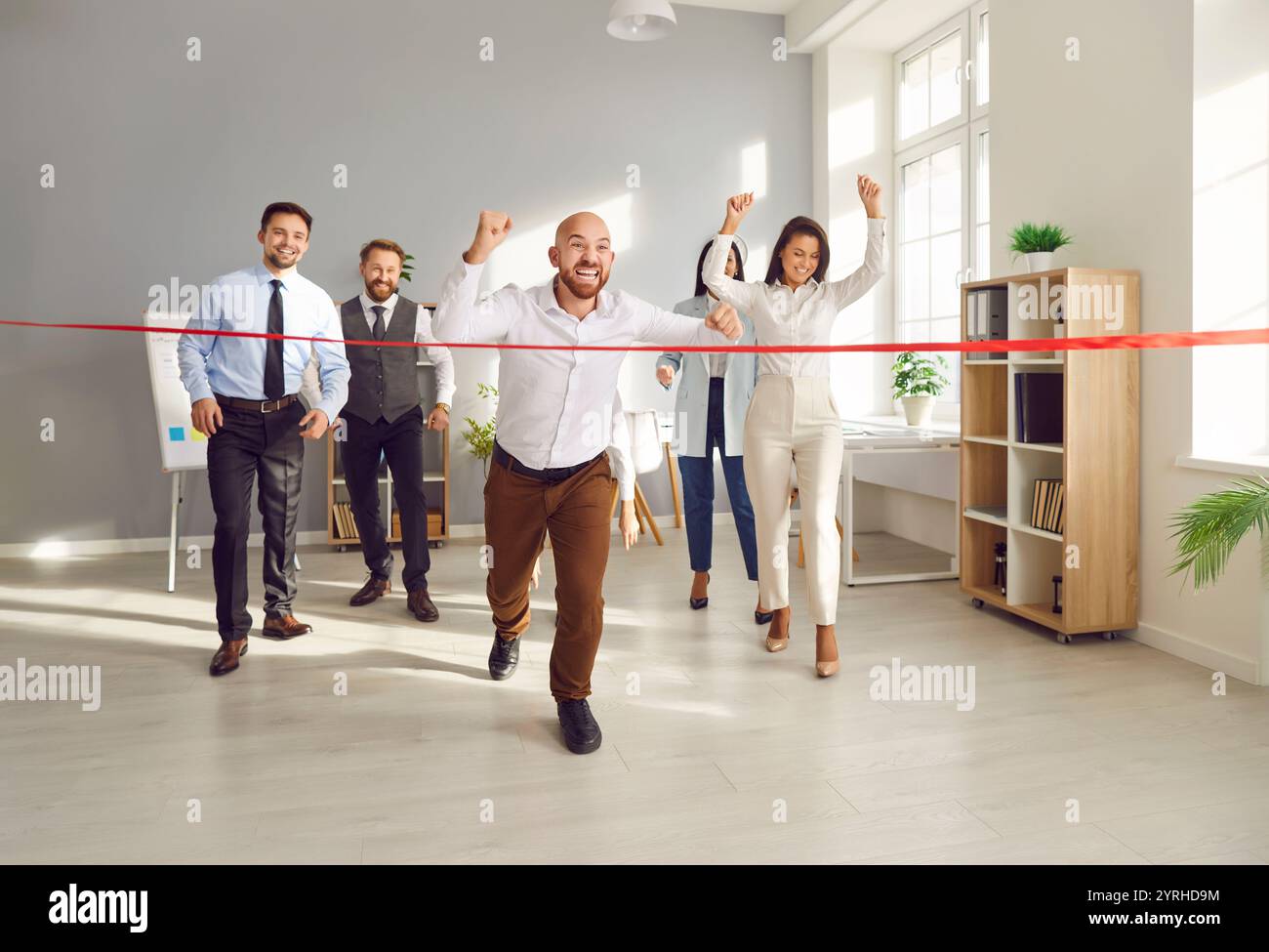 Man running to the red ribbon raising arms in the air celebrating ...
