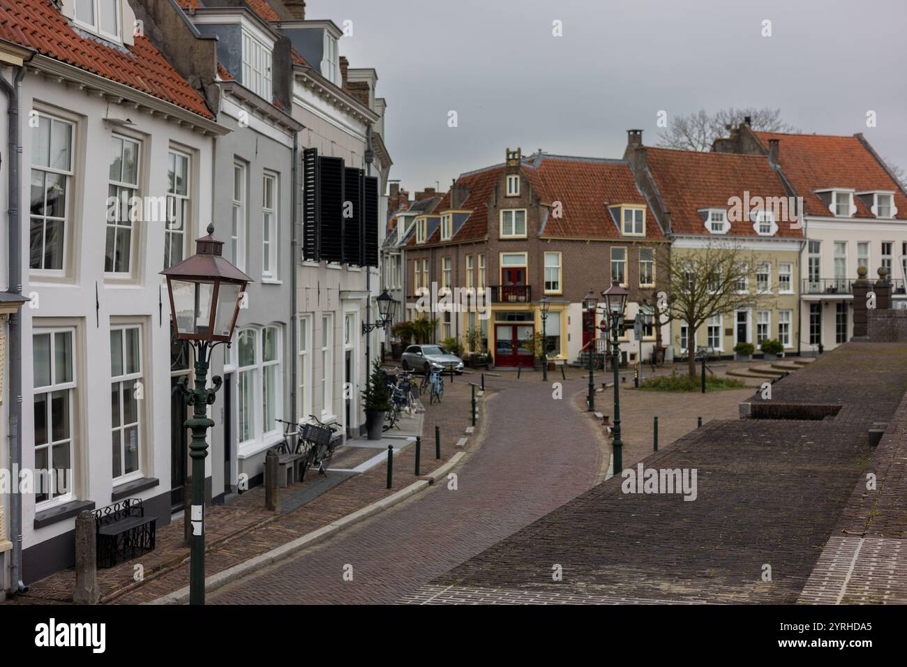 A quiet European street, charming historic houses, red-tiled roofs, and ...