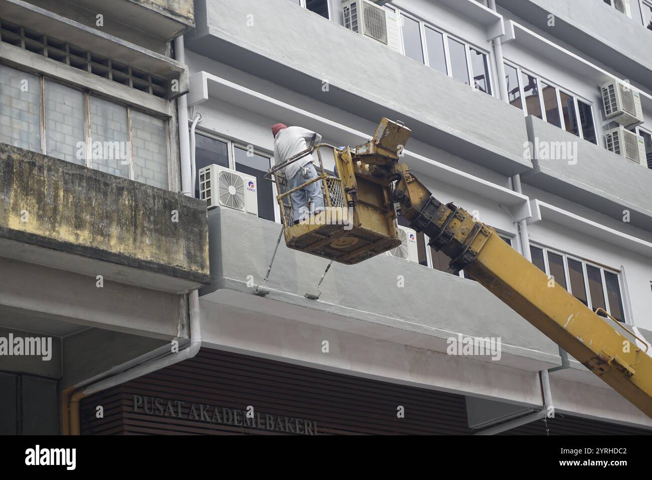 foreign worker painting a building in Malaysia Stock Photo - Alamy