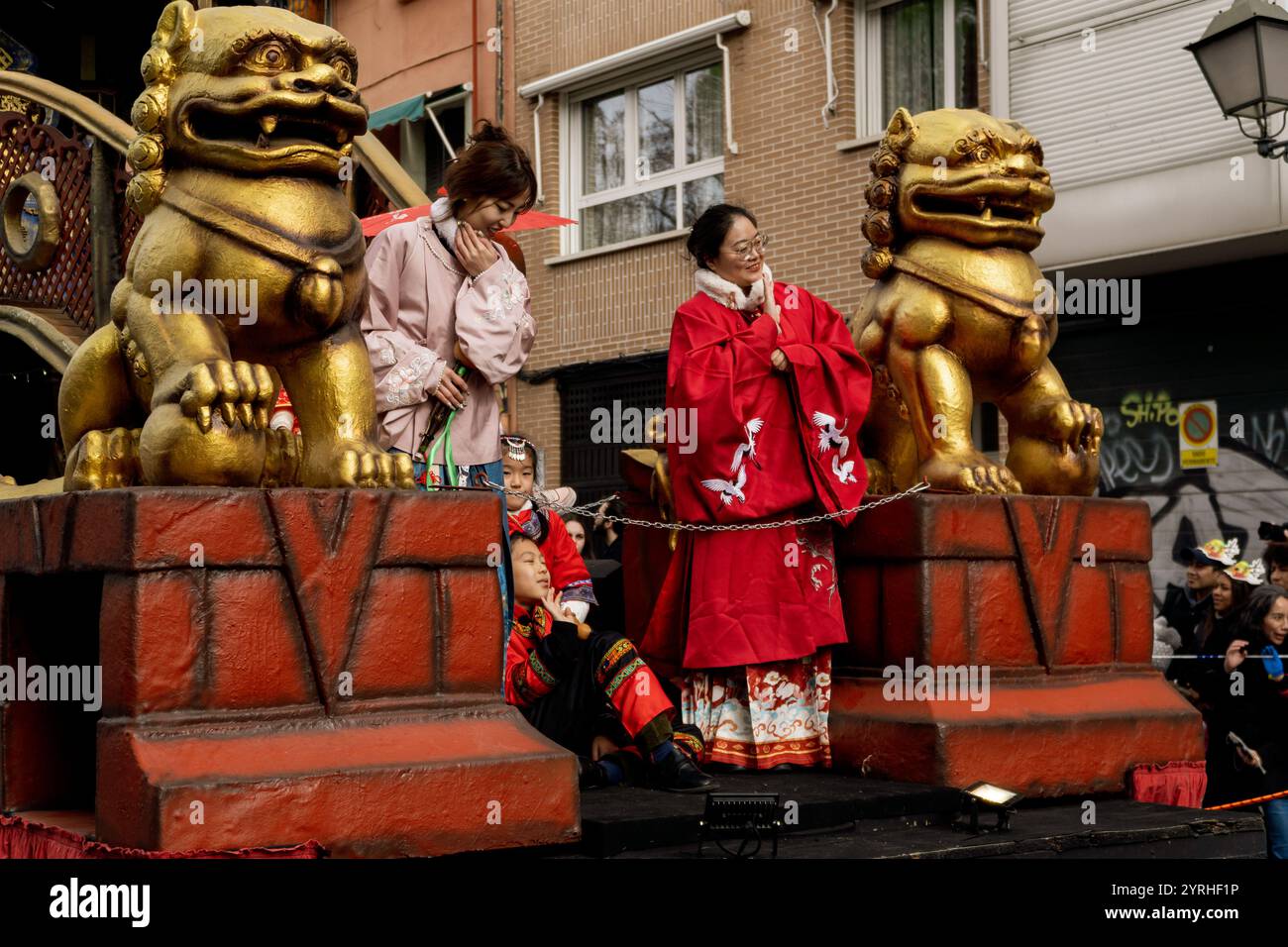 Happy Chinese young people between Fu lions sculptures on a Lunar New ...