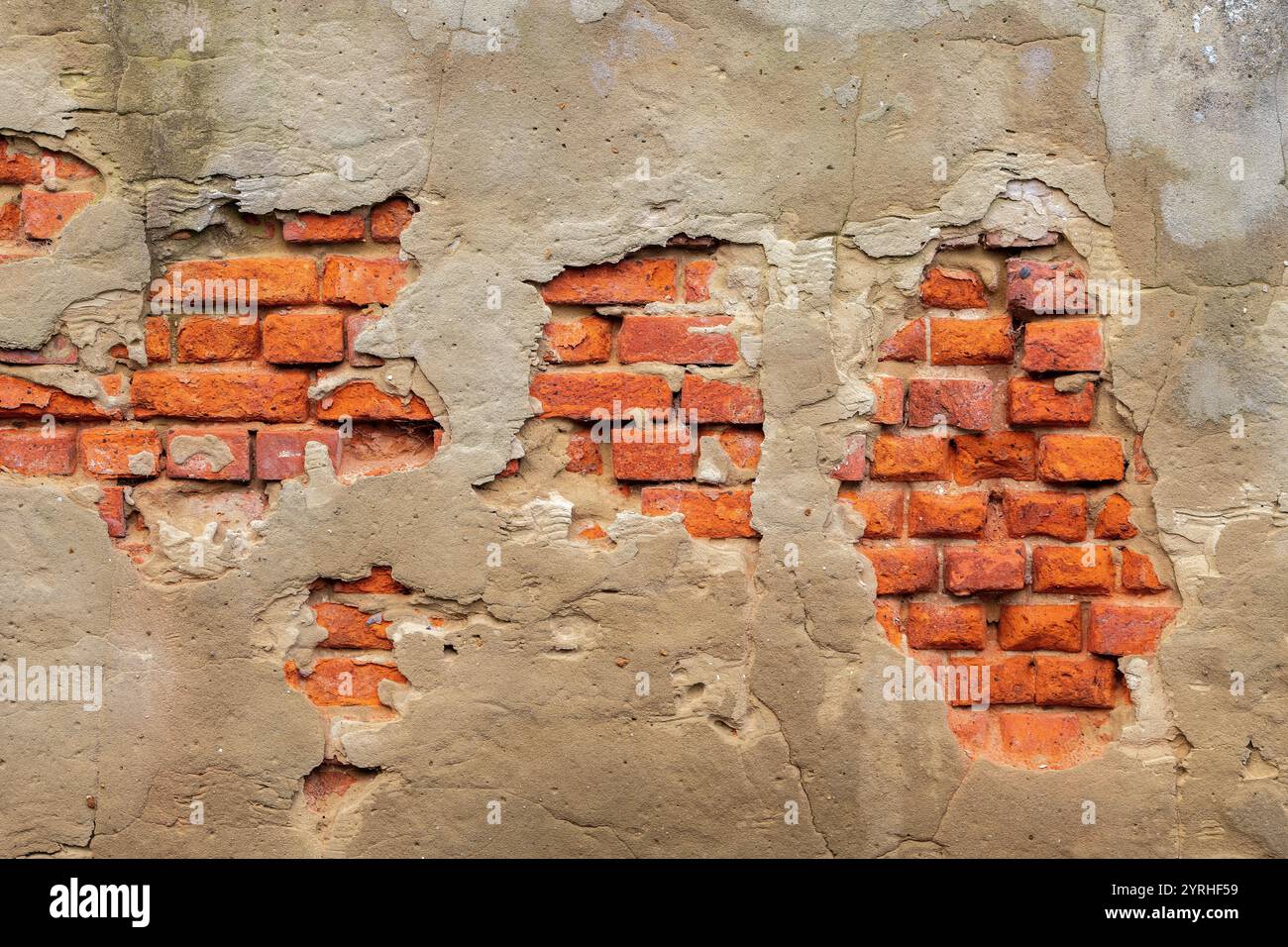 badly damaged and crumbling render on red brick wall, rendering falling ...