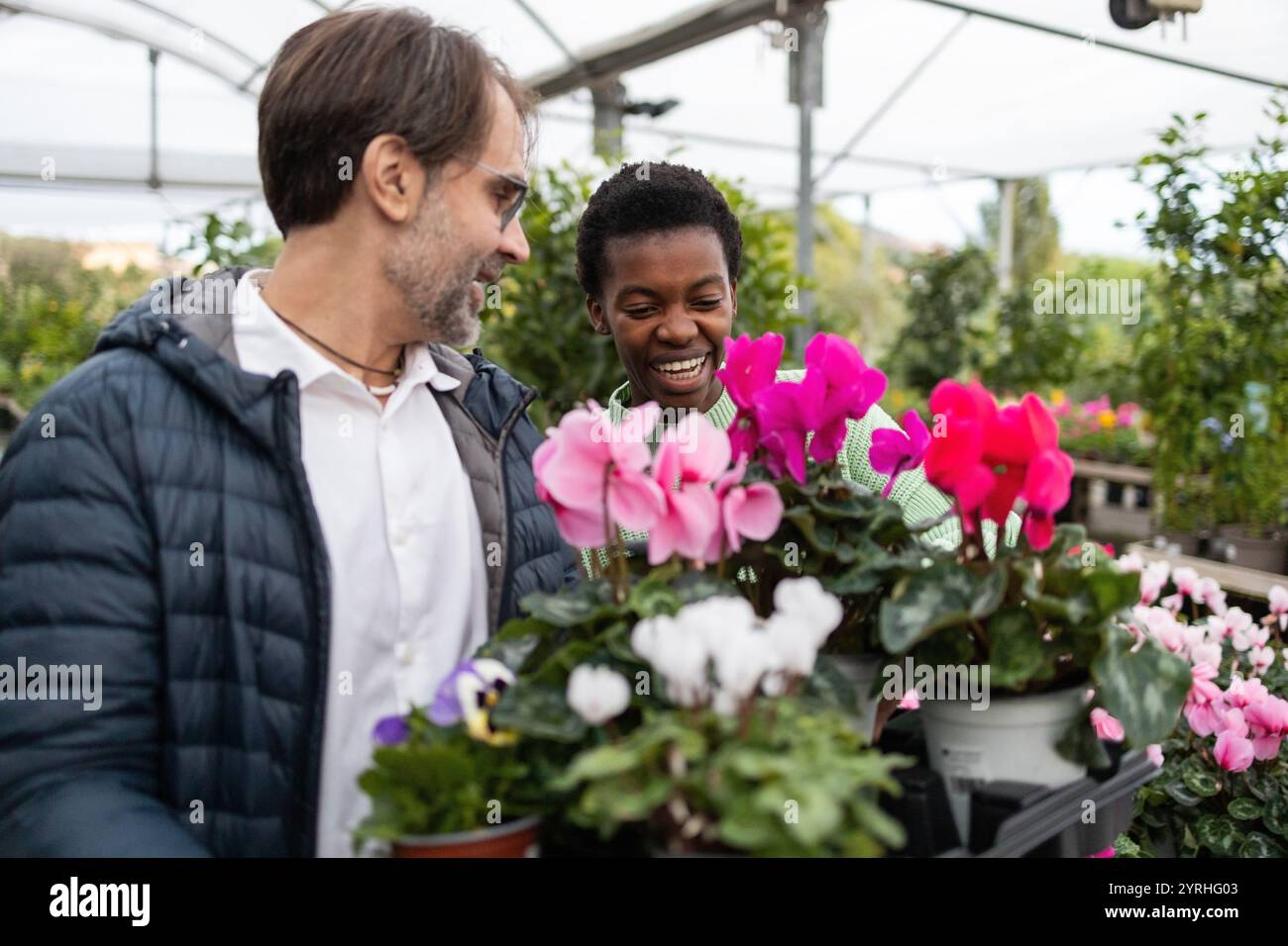 A happy duo explores a garden store, admiring bright pink and white ...