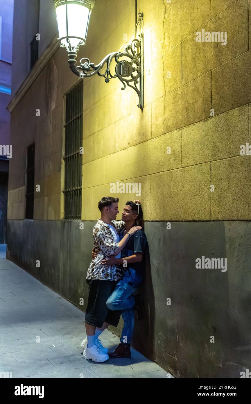 A young couple shares a tender embrace under a vintage street lamp in a ...
